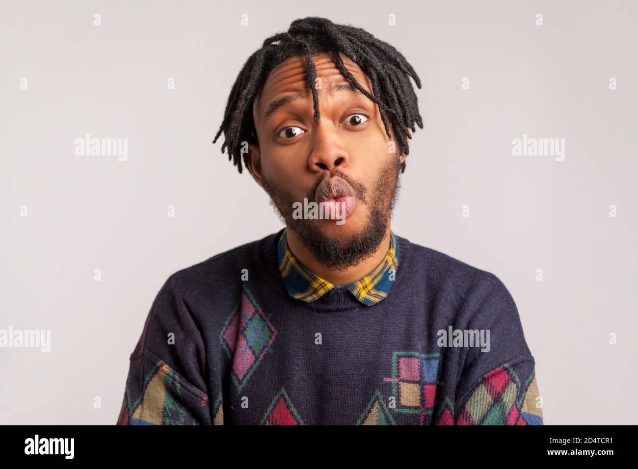 Funny childish african man with dreadlocks and beard making fish face ...