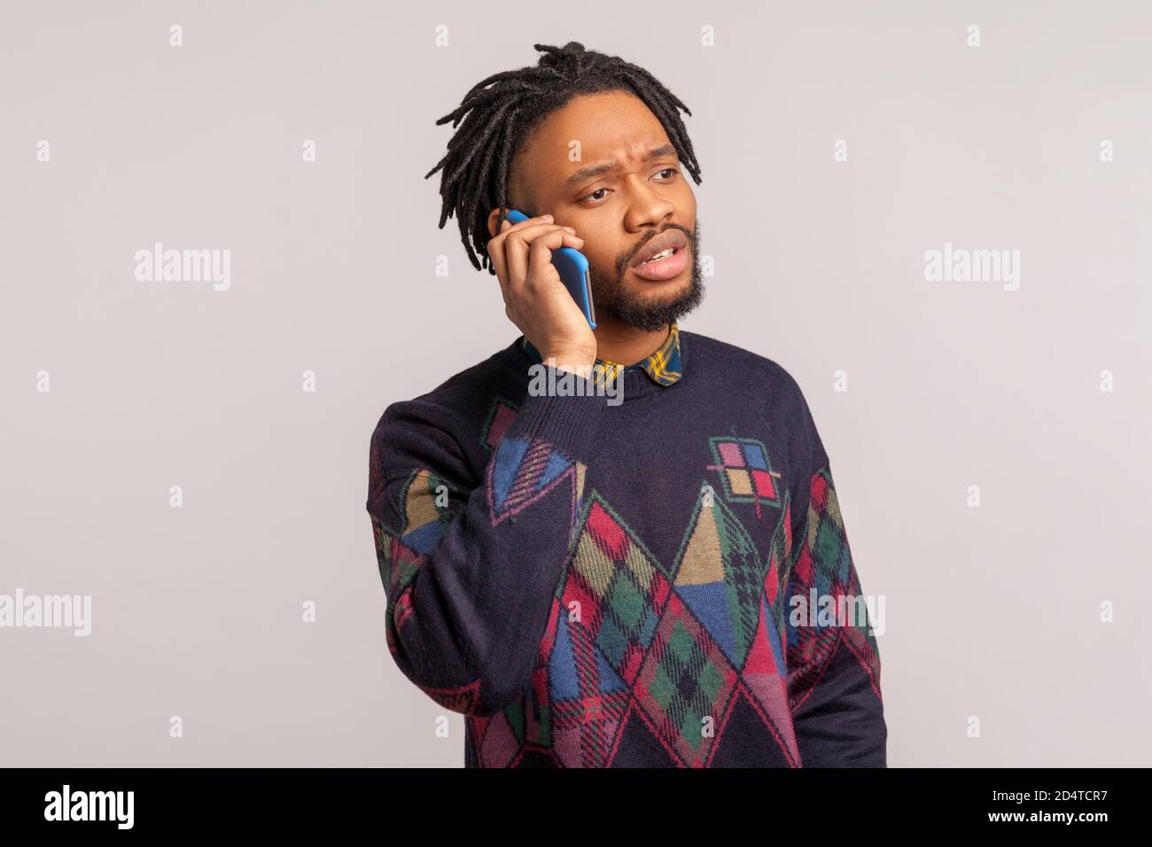 Concerned african man with dreadlocks speaking cell phone, discussing ...