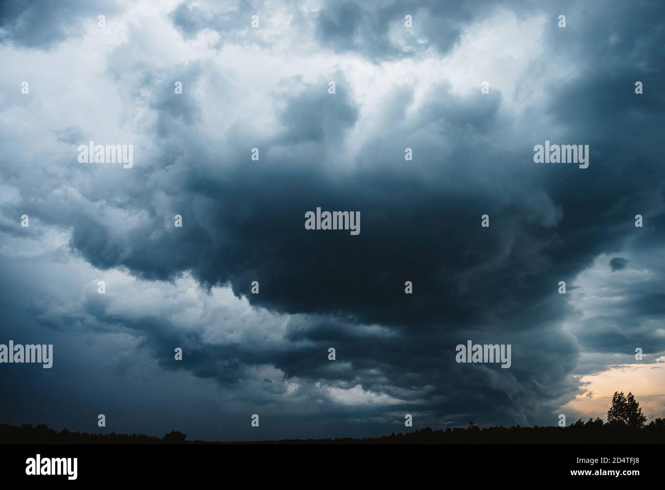 Dramatic cloudscape. Sunny light through dark heavy thunderstorm clouds ...