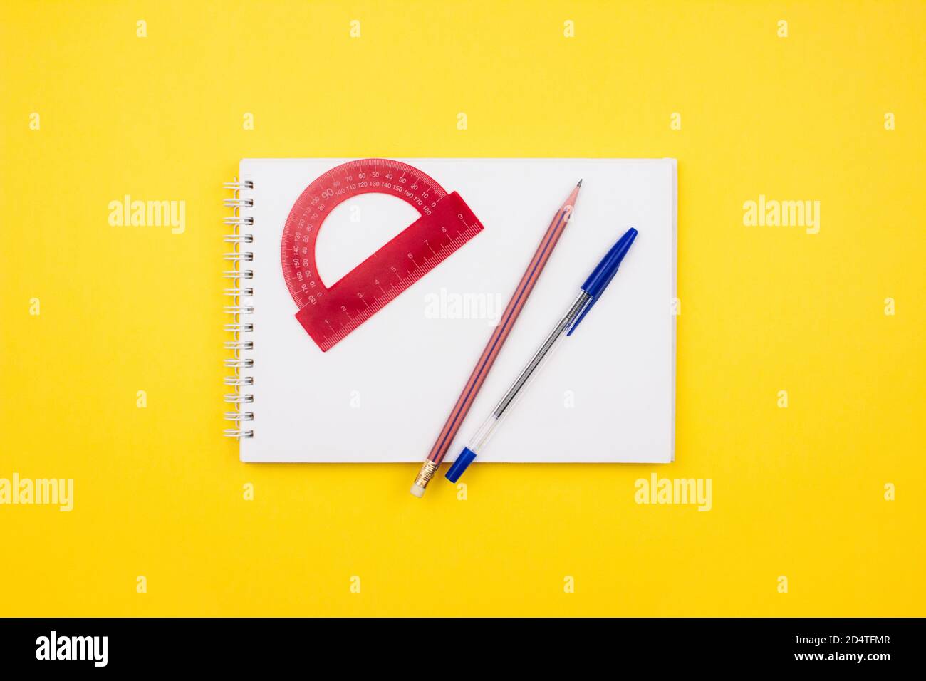 School and office supplies on yellow background. Protractor, sketchbook ...