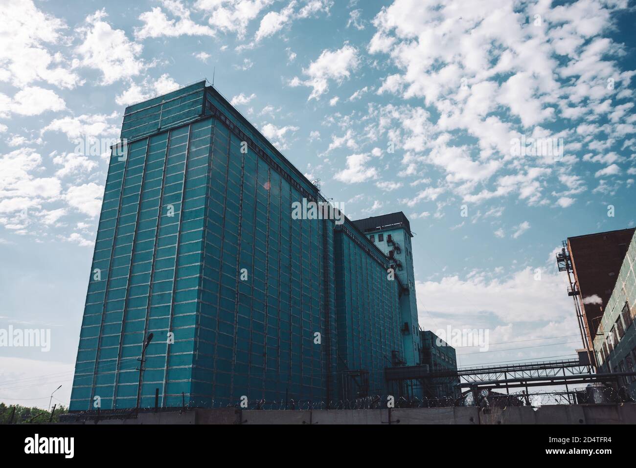 Giant multistory production building behind fence with barbed wire ...