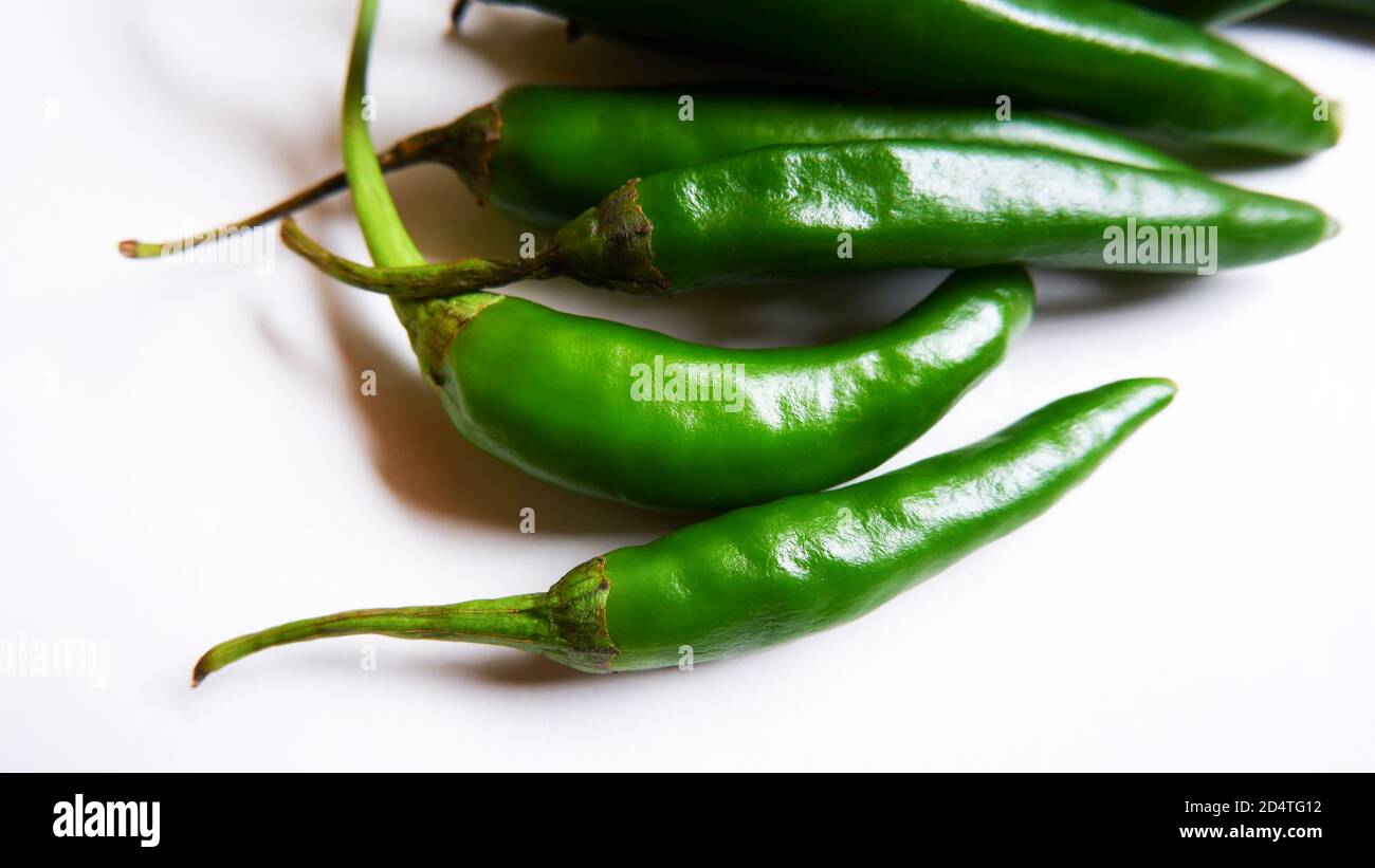 a shot of Indian fresh green chillies isolated on white background ...