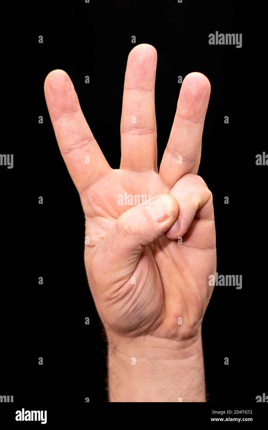 male hand on a black background three fingers raised up Stock Photo - Alamy