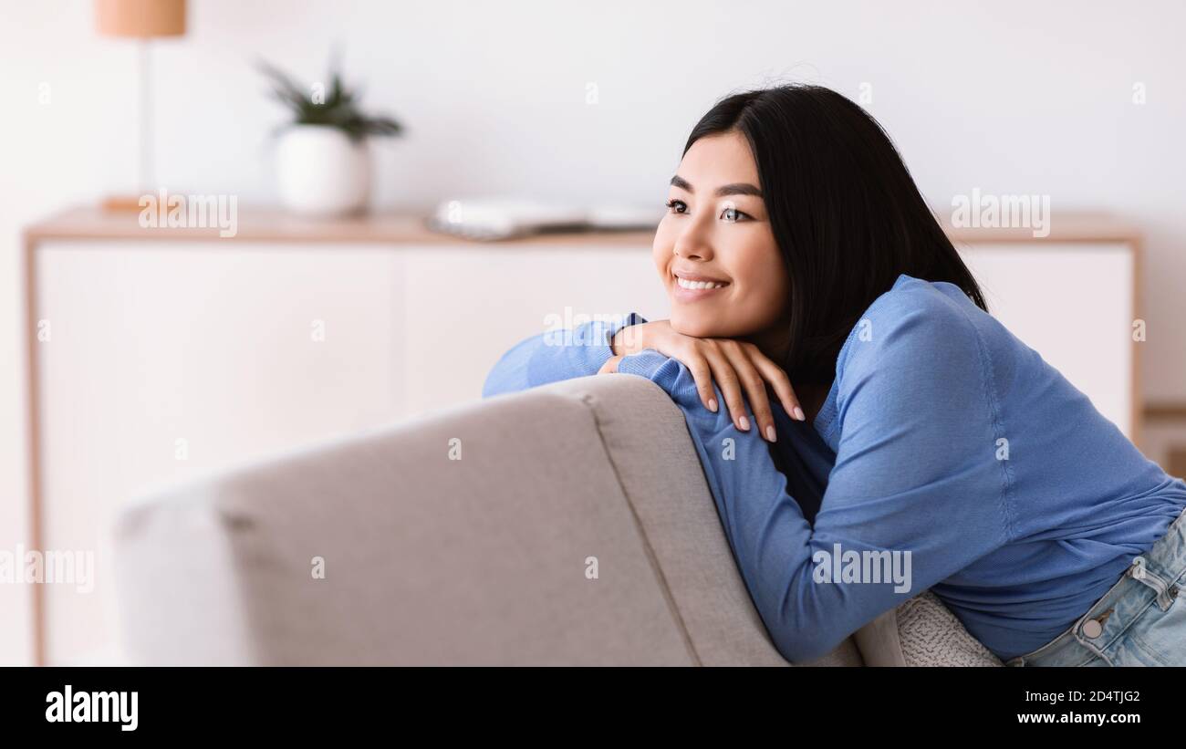 Asian woman having rest at home on the sofa Stock Photo - Alamy