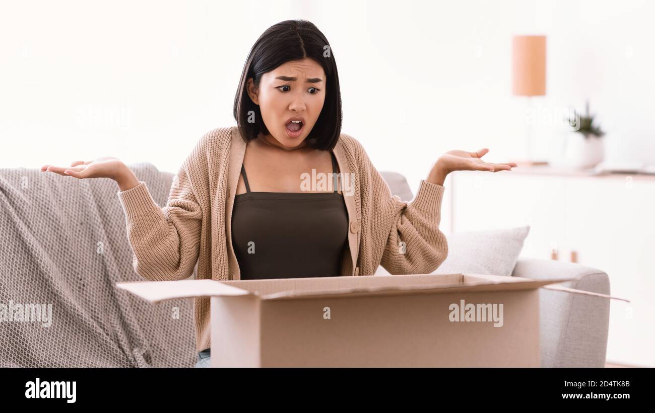 Angry asian woman unpacking wrong parcel, delivery mistake Stock Photo ...