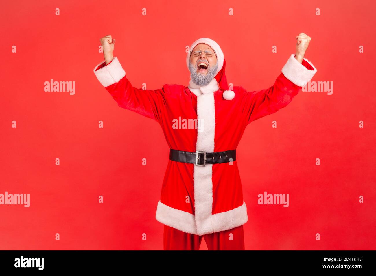 Portrait of extremely happy satisfied santa claus rising hands up and ...