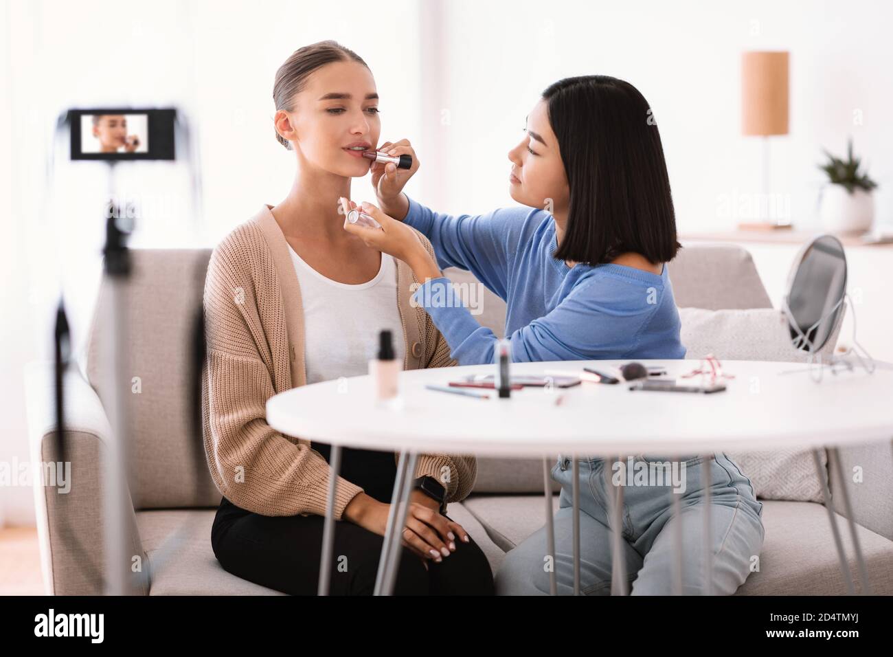 Asian Woman Doing Makeup For Her Beautiful Model Stock Photo - Alamy