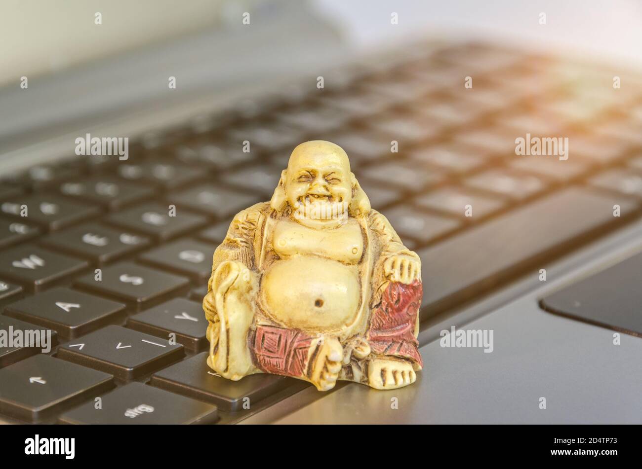 Buddha statue on computer keyboard symbolizing stress reduction and ...