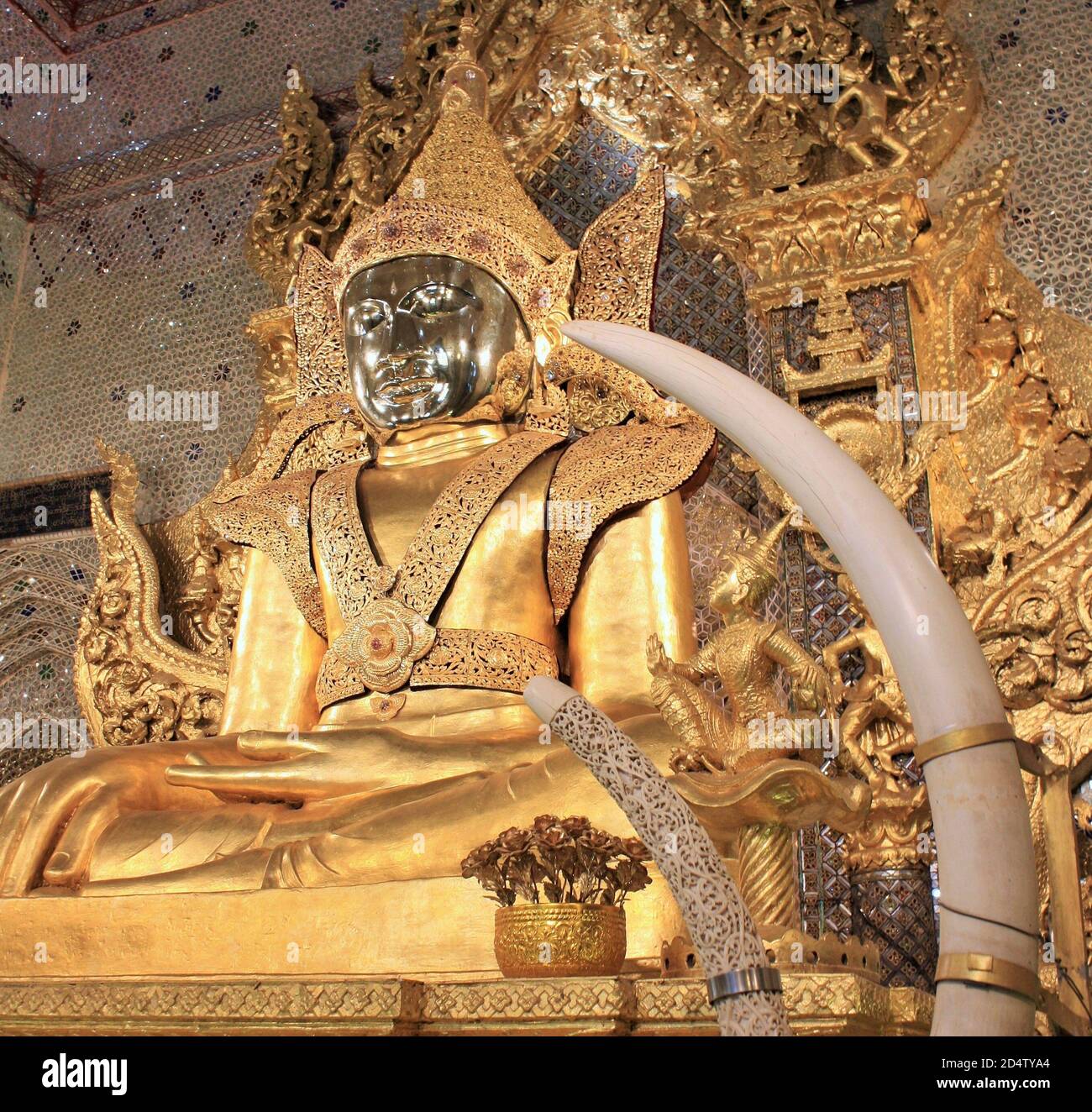 Sacred Mahamuni Buddha golden statue with carved ivory elephant tusks ...