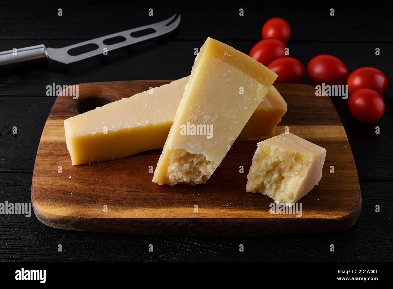 Wedge of italian hard cheese Parmesan or Grana Padano on a brown wood ...