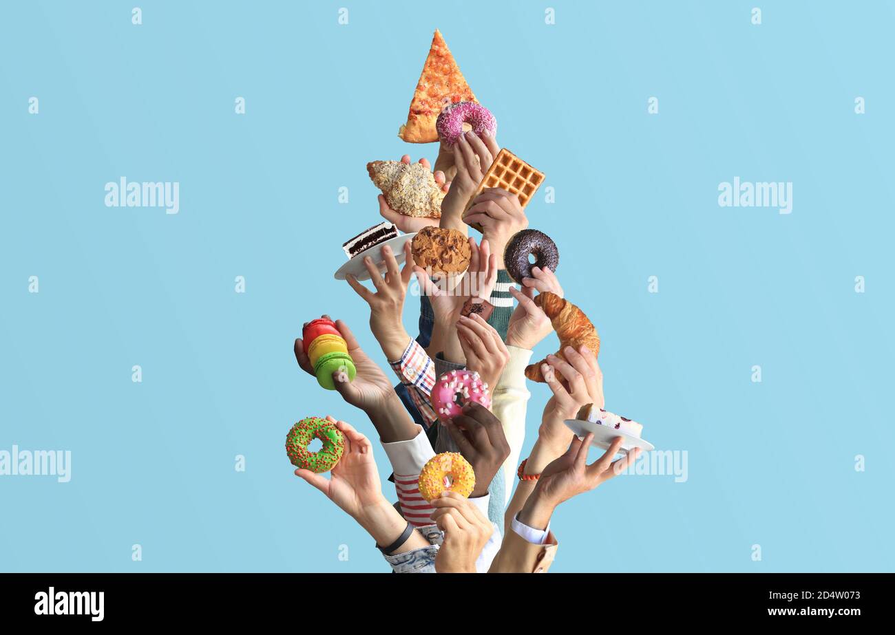 People are holding different desserts in their hands. The concept of ...