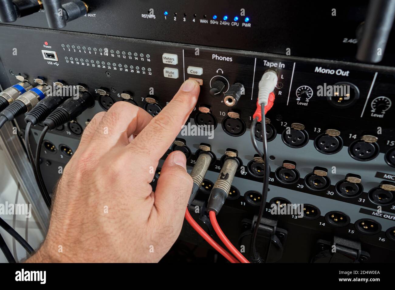 White or Caucasian hand presses a button on an input and output panel ...