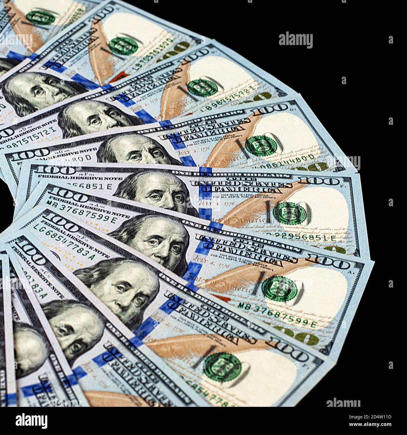 Close-up of US dollars fanned out on a black background. There are a ...