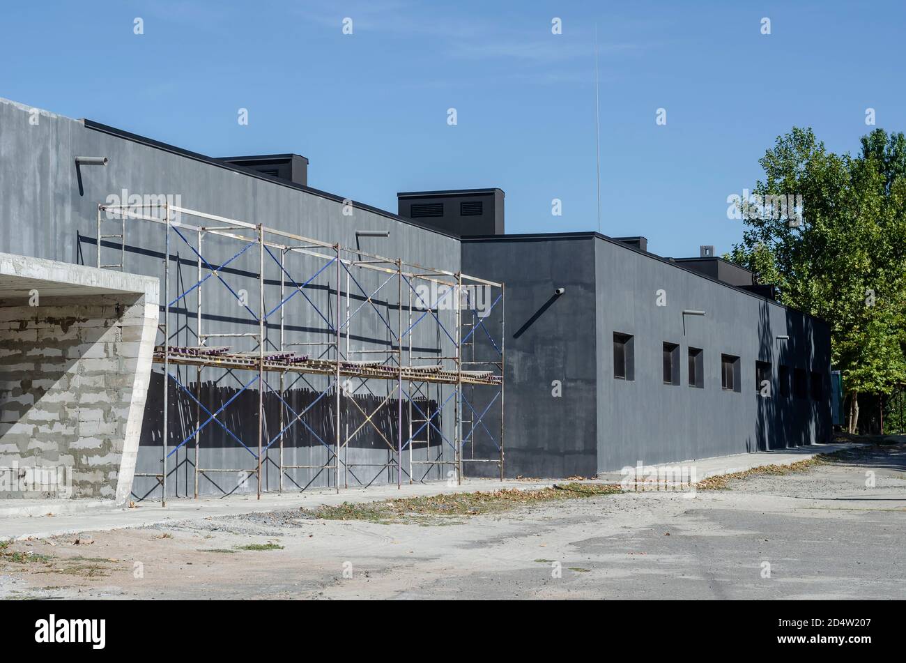 Scaffolding near a gray one-story building. Repair and reconstruction ...