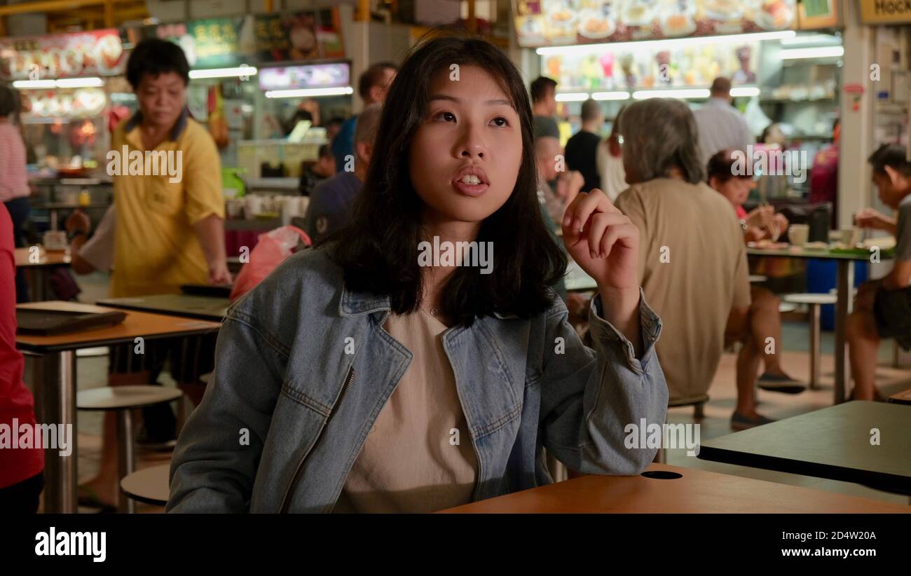Young Chinese College Girl Ordering Food At A Busy Crowded Singapore ...