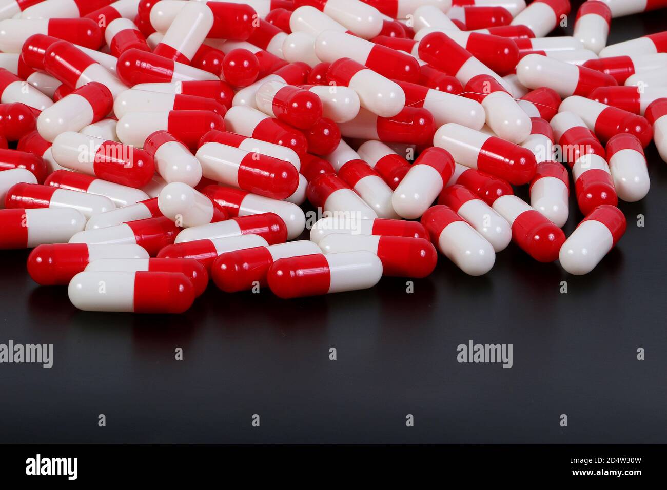 Pile of red and white medical tablets on a black background Stock Photo ...