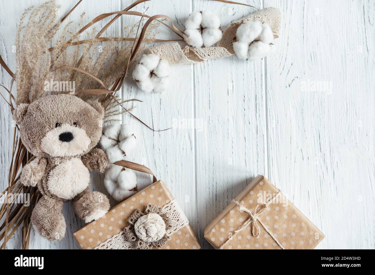 Winter composition with dry plants, gift boxes and a toy bear on a ...