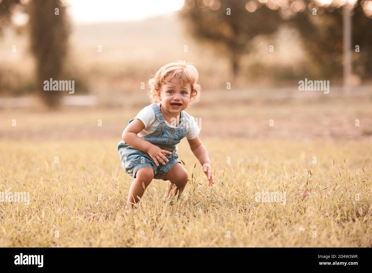 Crying kid girl 1-2 yea rold outdoors. Sad child over nature background ...