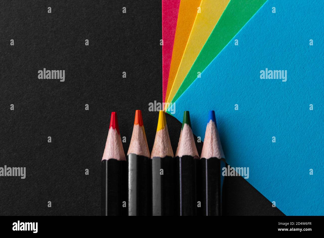 Colored rainbow paper corners and Black wooden colored pencil set on ...