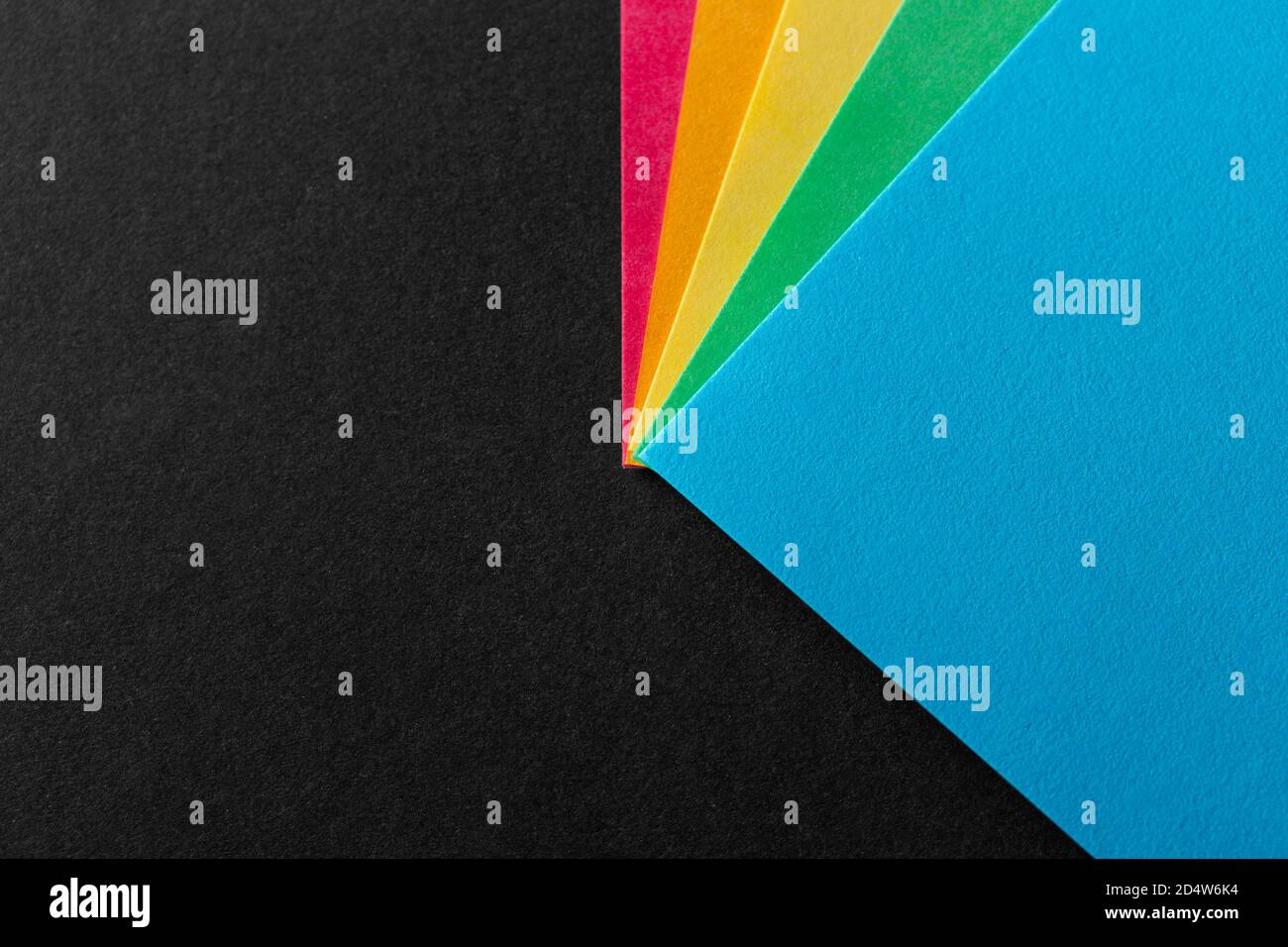 Colored rainbow paper corners on black textured background. Business ...