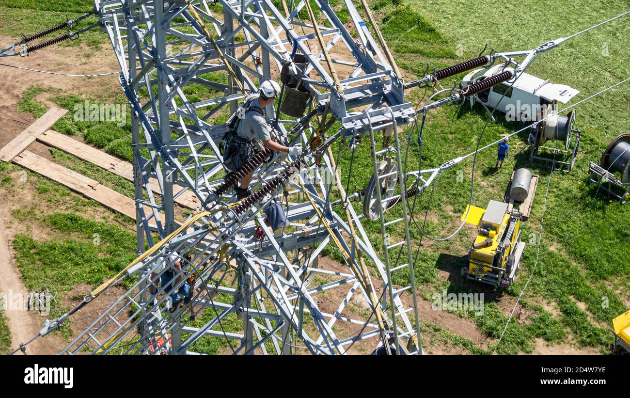 Overhead lineman & industrial climbers, working on a pylon in Bavaria ...