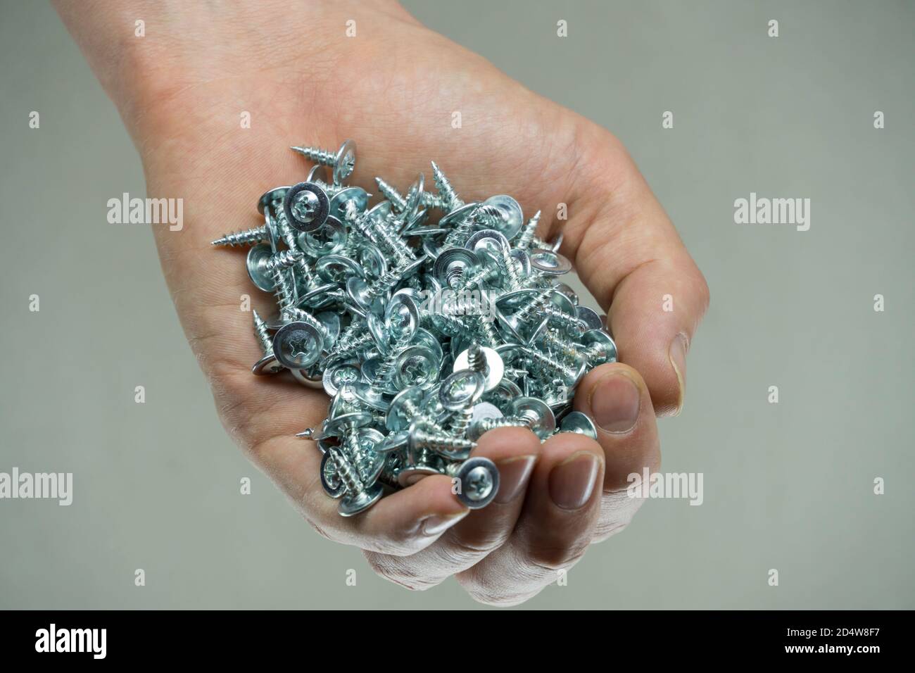 Hold a set of cogs in your hand. Bolts in a man's hand. Screws and cogs ...