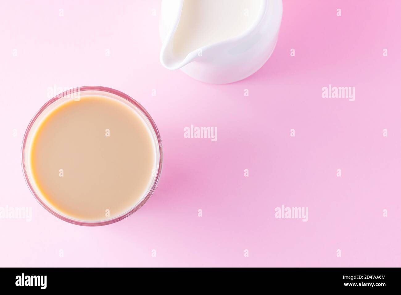 Milk tea on a pink background. Glass of masala chai tea and milk jug ...