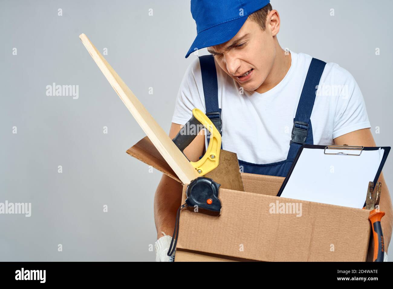 man in working uniform with a box in his hands tools loader delivery ...