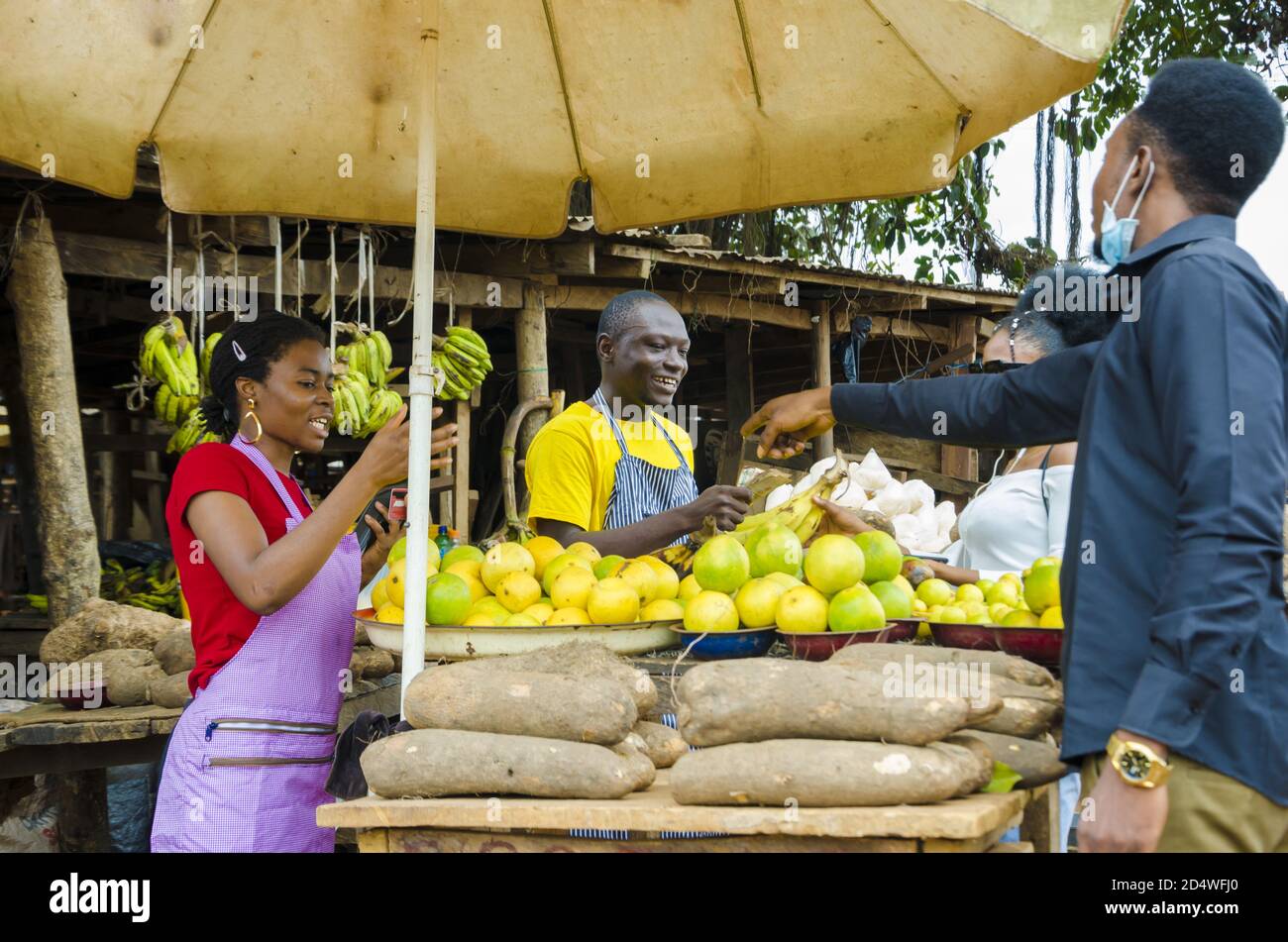African customer with a face mask making transaction with African ...