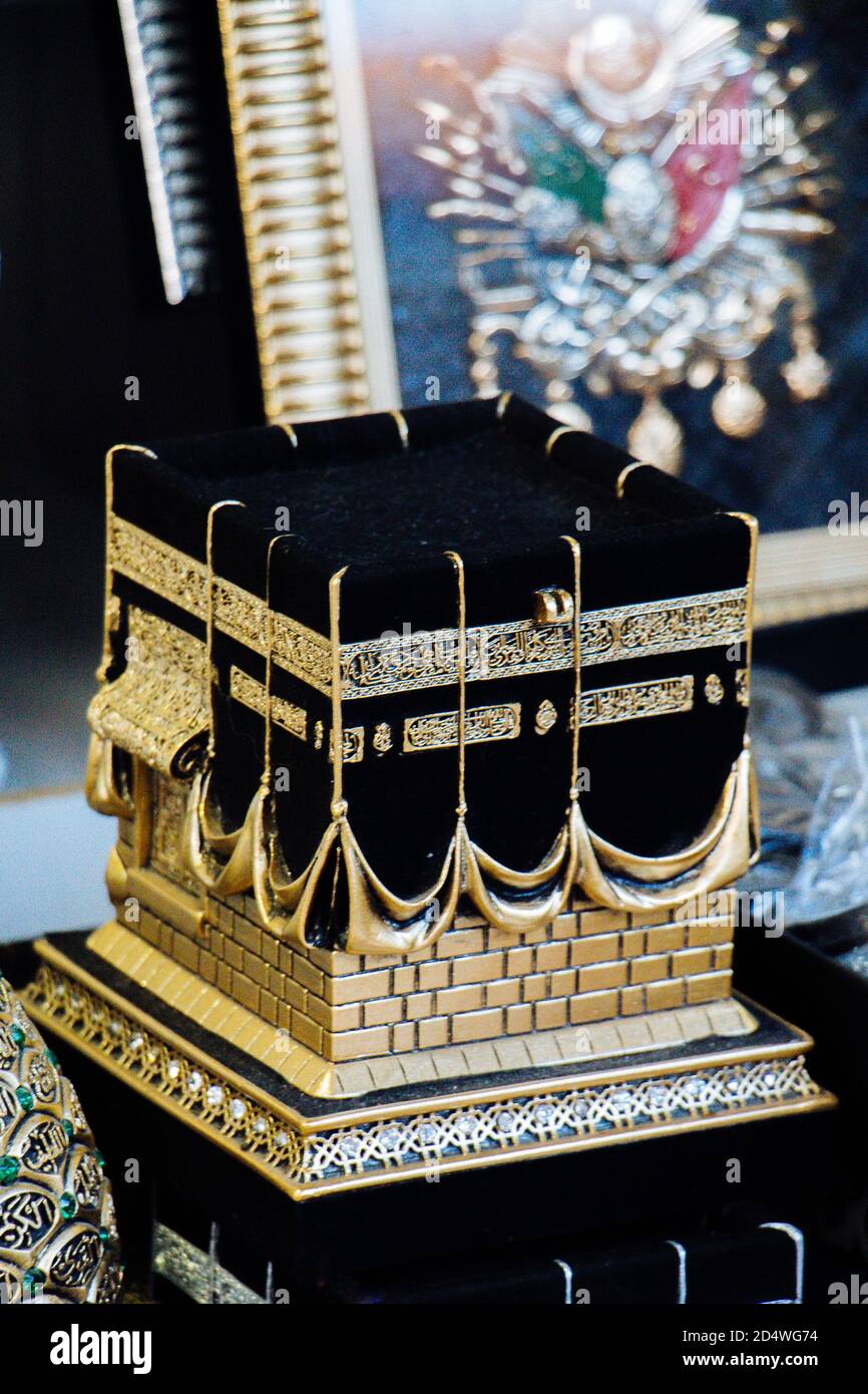 Vertical shot of a miniature of Kaaba under the lights with a blurry ...