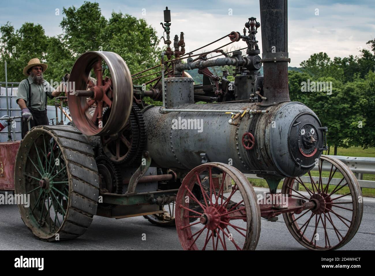 Two amish men slow traffic on no passing zone of highway with steam ...