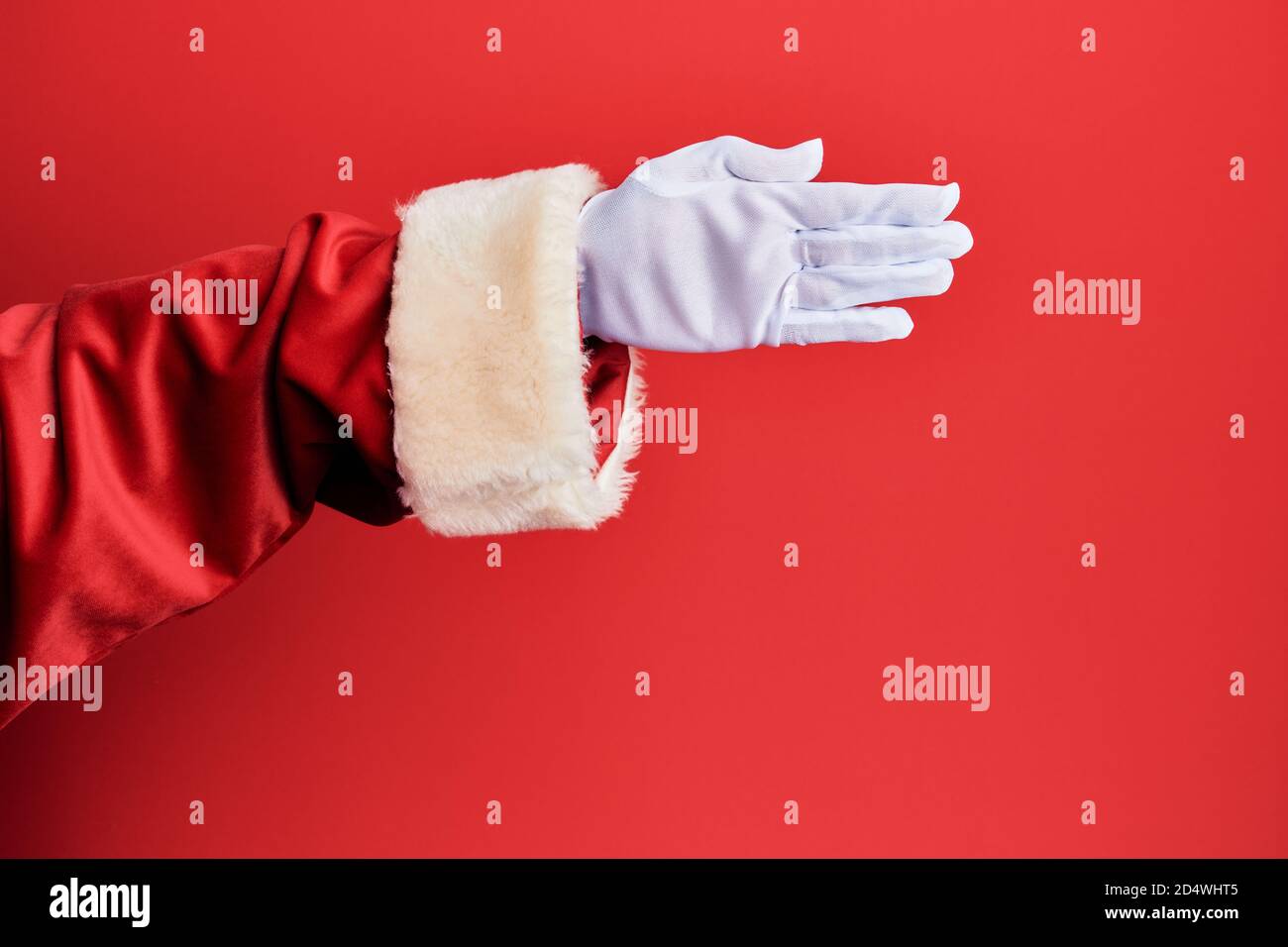 Hand of a man wearing santa claus costume and gloves over red ...