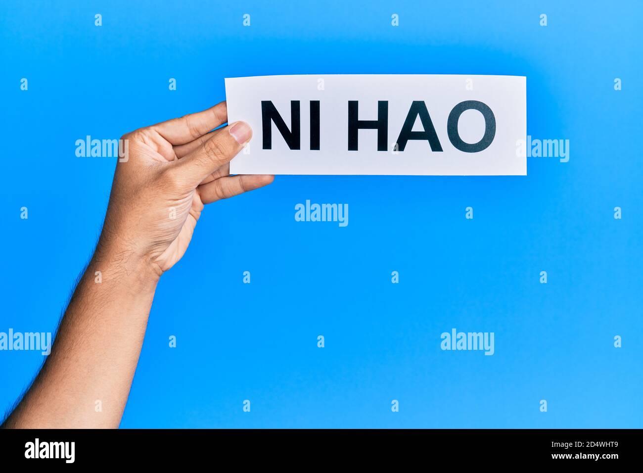 Hand of hispanic man holding chinese greeting ni hao word paper over ...