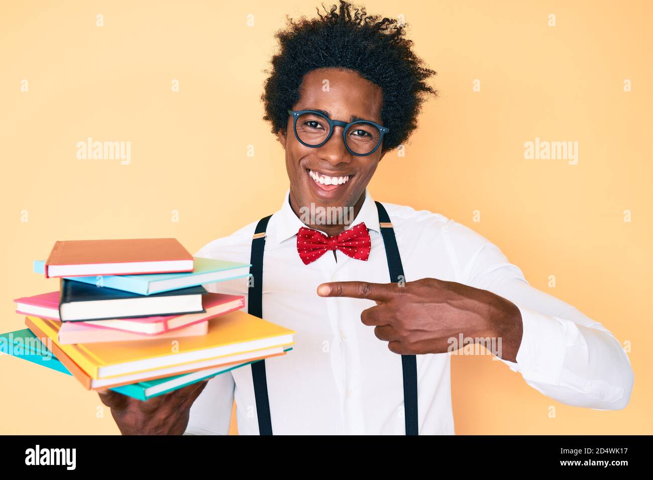 Handsome african american nerd man with afro hair holding books smiling ...