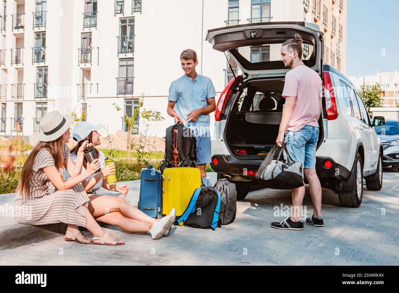 friends load car trunk with baggage Stock Photo - Alamy
