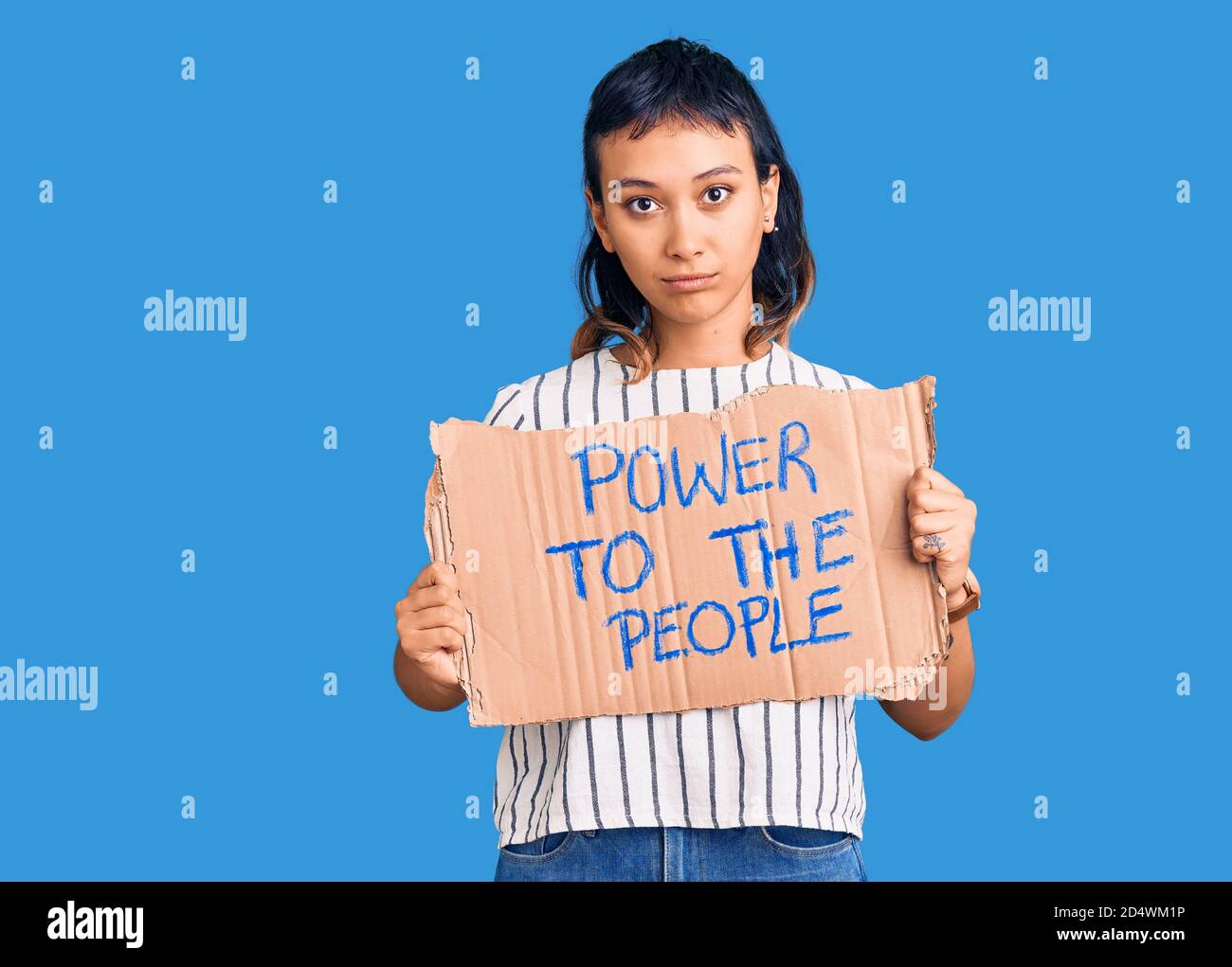Young woman holding power to the people banner thinking attitude and ...