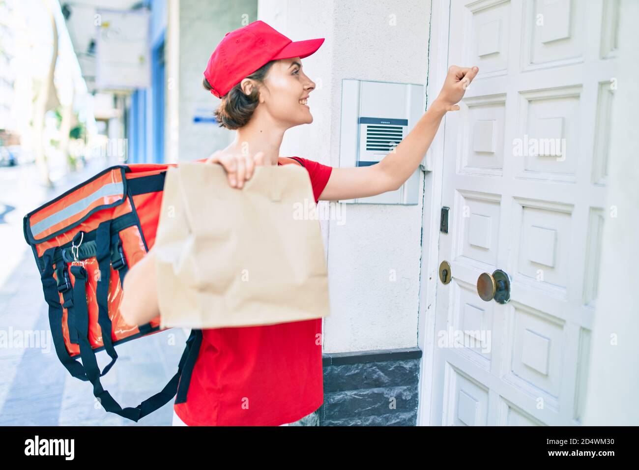 Delivery business worker woman wearing uniform smiling happy knocking ...