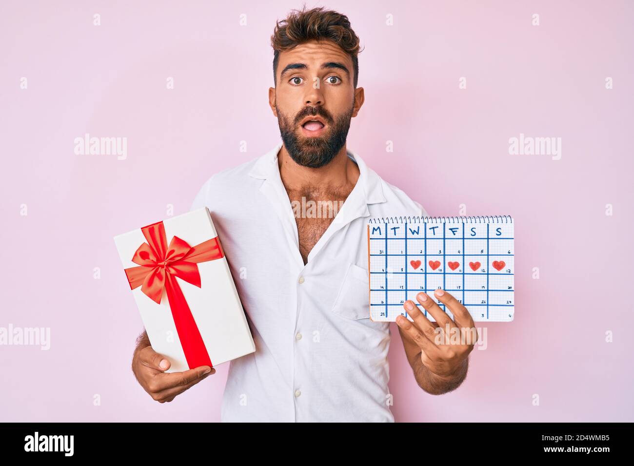 Young hispanic man holding heart calendar and paper airplane annoyed ...