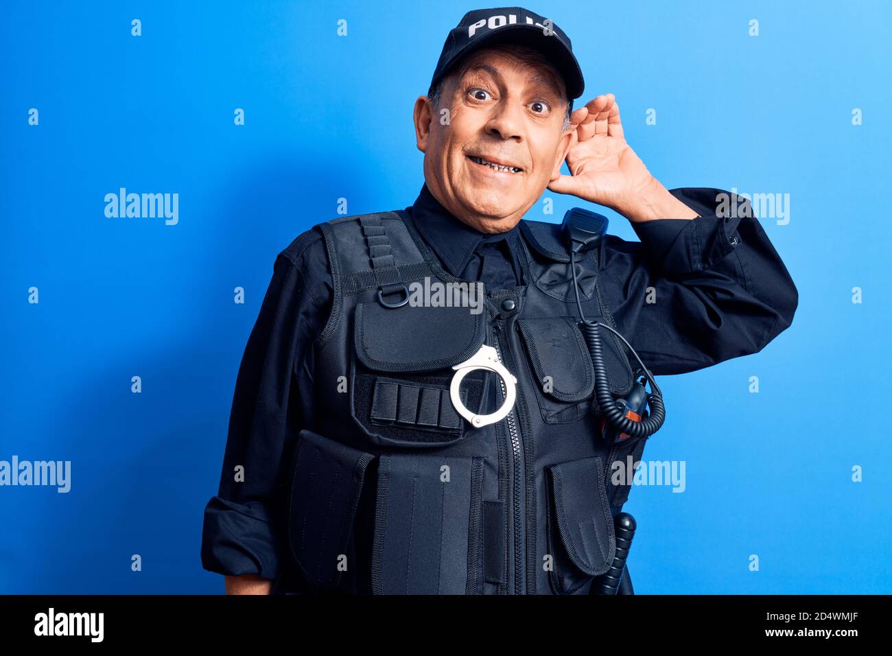 Senior man with grey hair wearing police uniform smiling with hand over ...