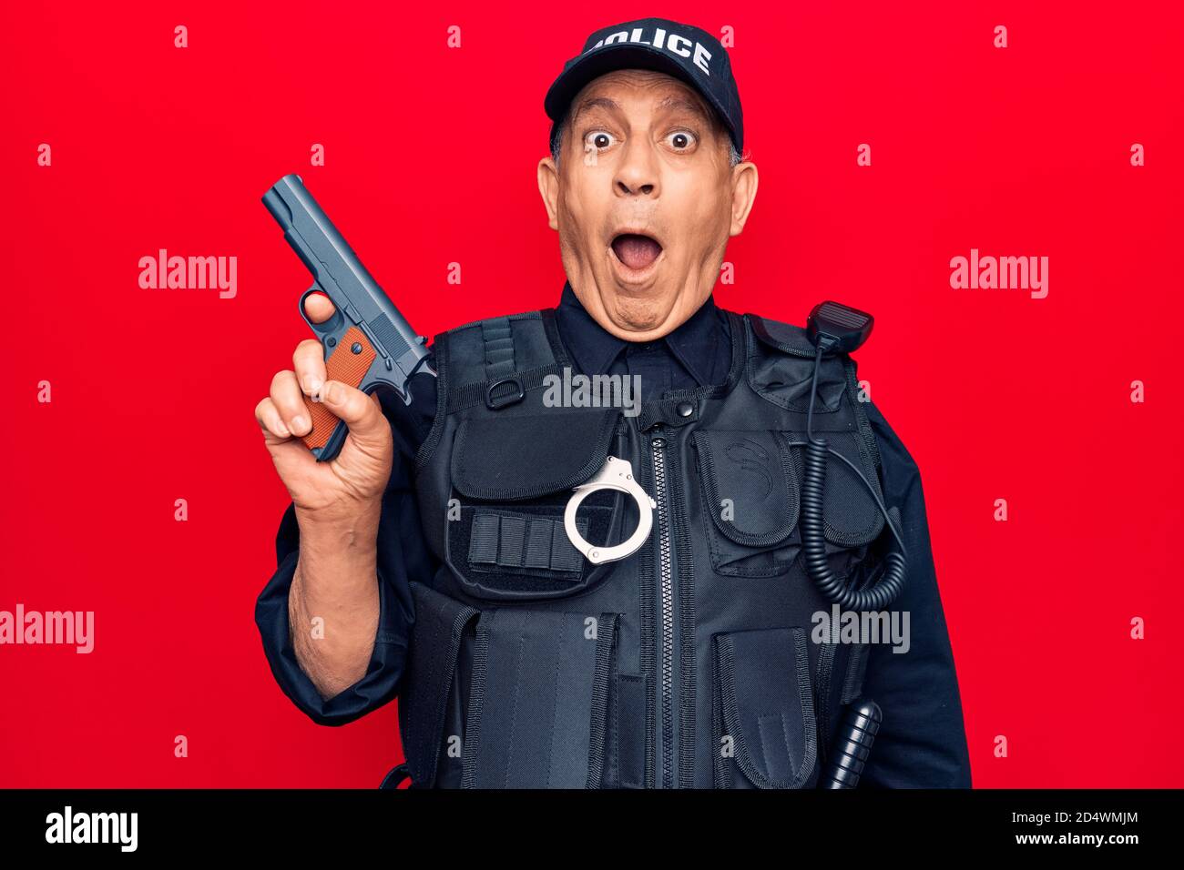 Senior man with grey hair wearing police uniform holding gun scared and ...