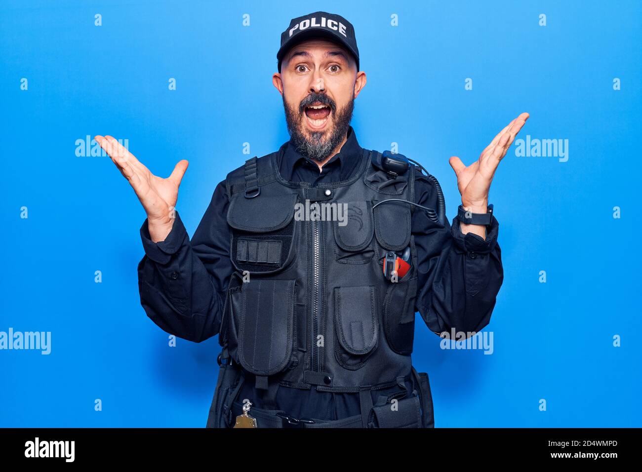 Young handsome man wearing police uniform celebrating victory with ...