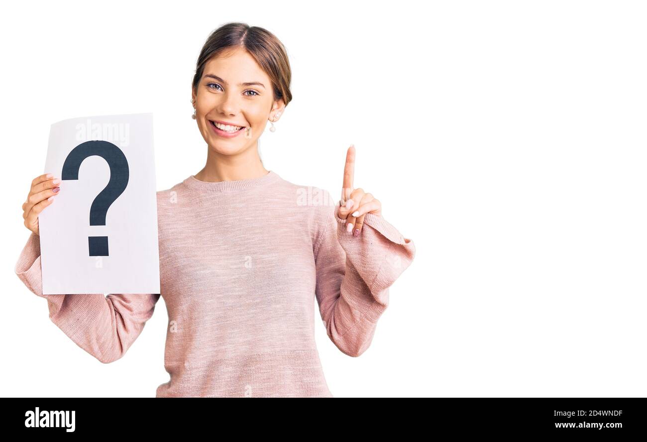 Beautiful caucasian woman with blonde hair holding question mark ...