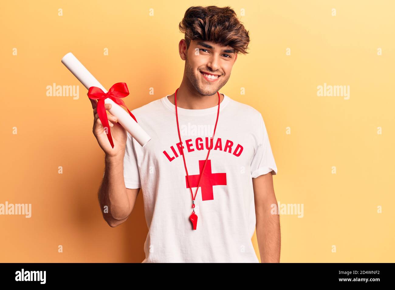 Young hispanic man wearing lifeguard t shirt using binoculars looking ...