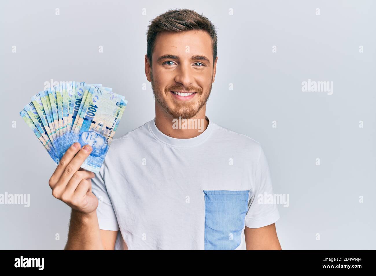 Handsome caucasian man holding south african rand banknotes looking ...