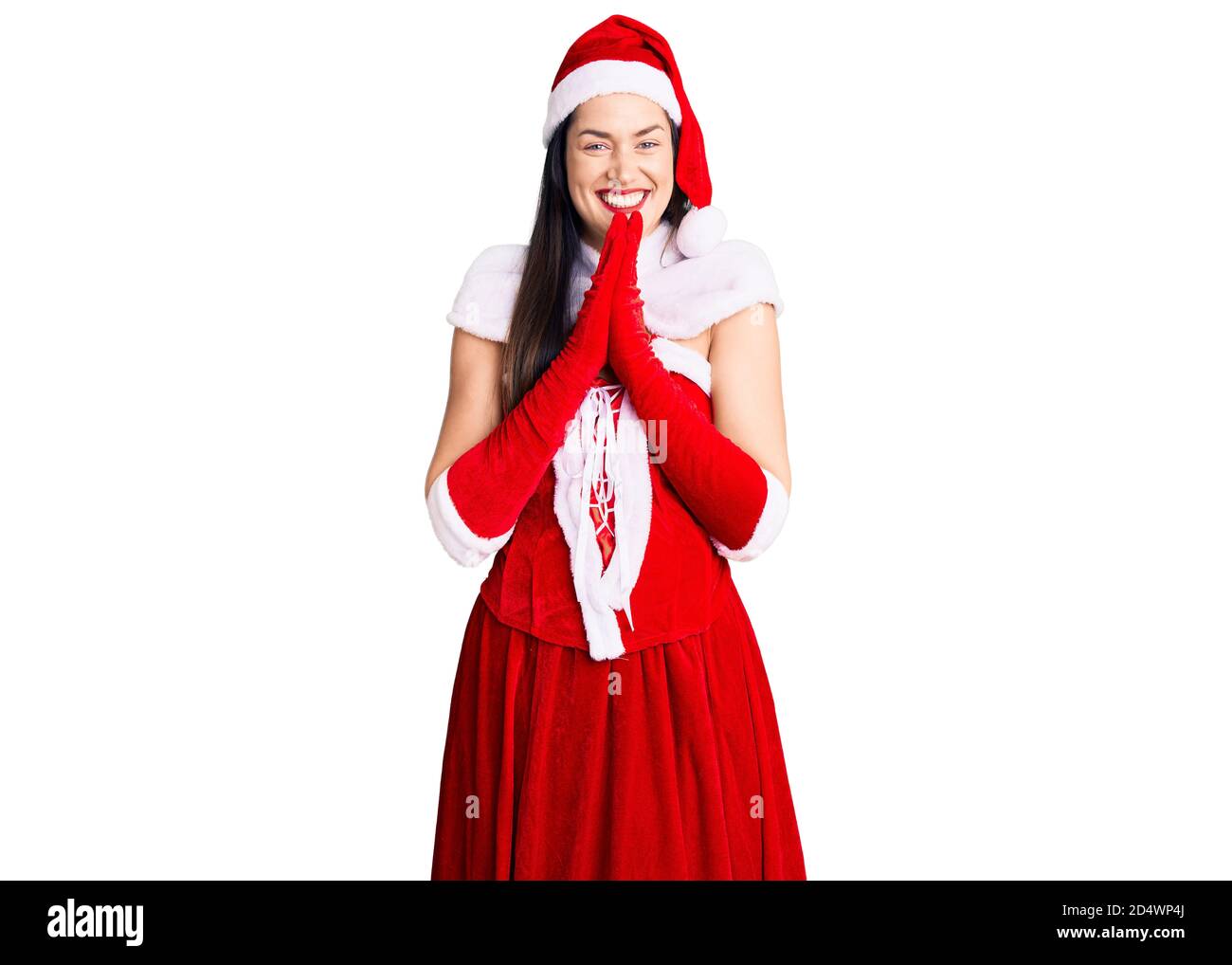 Young beautiful caucasian woman wearing santa claus costume praying ...