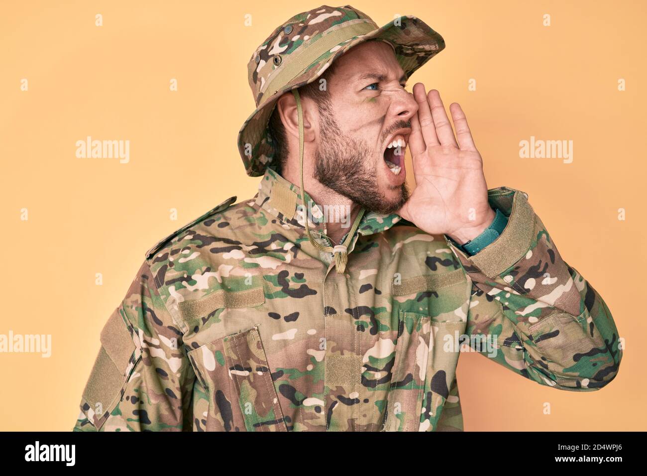 Young caucasian man wearing camouflage army uniform shouting and ...