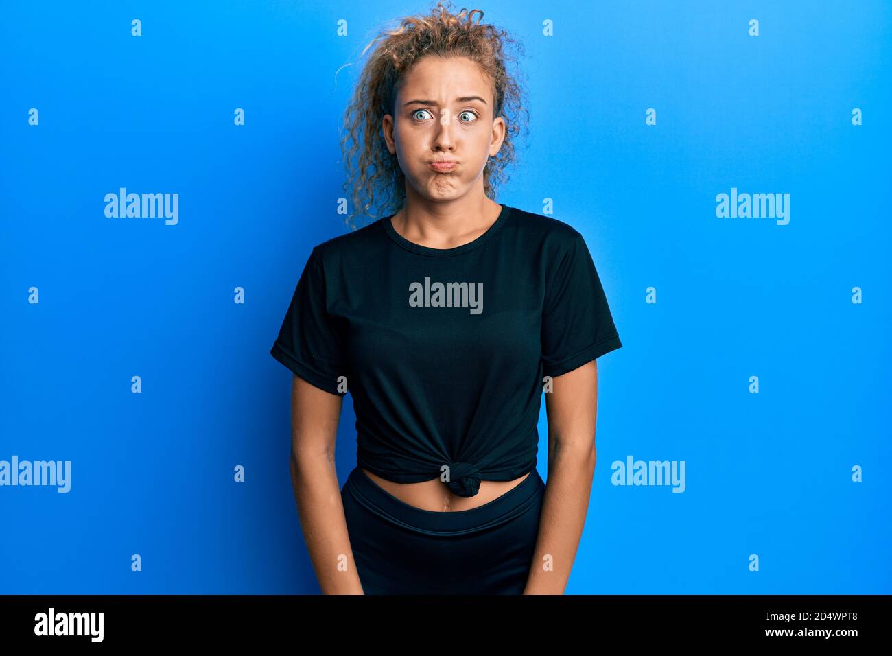 Beautiful caucasian teenager girl wearing black sportswear puffing ...
