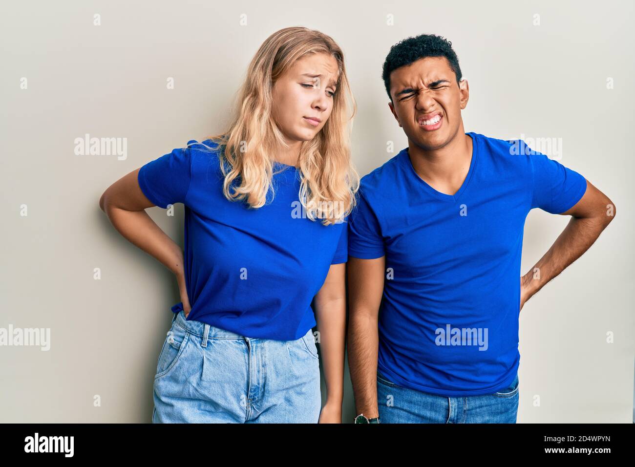 Young interracial couple wearing casual clothes suffering of backache ...