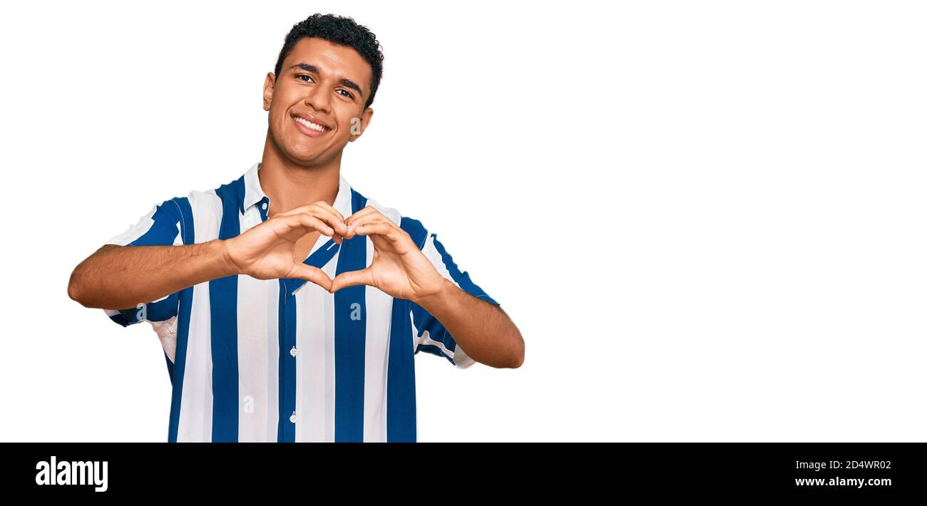 Young arab man wearing casual clothes smiling in love doing heart ...