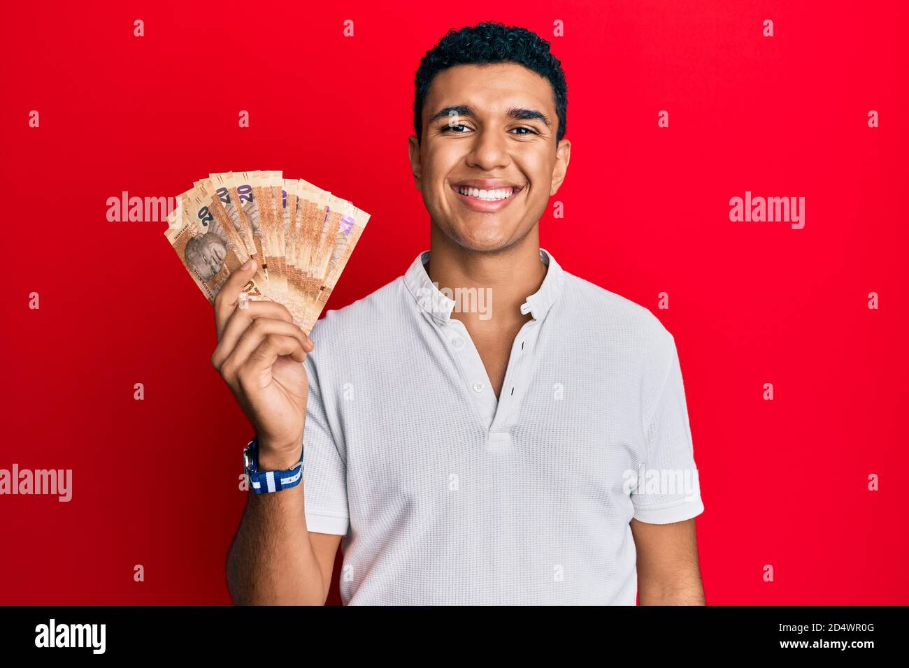 Young arab man holding south african rand banknotes looking positive ...